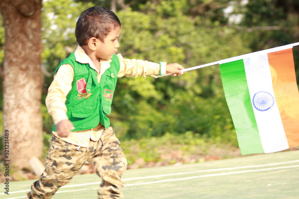 little indian boy proudly holding Indian National flag. The national ...