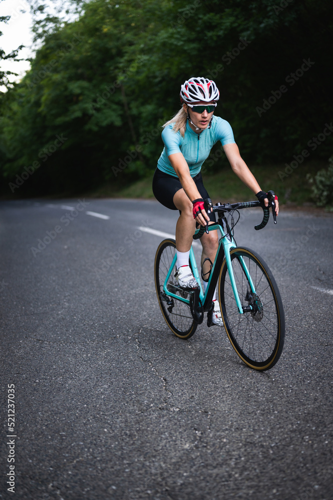 Professional female cyclist trains in the woods. Woman riding race ...