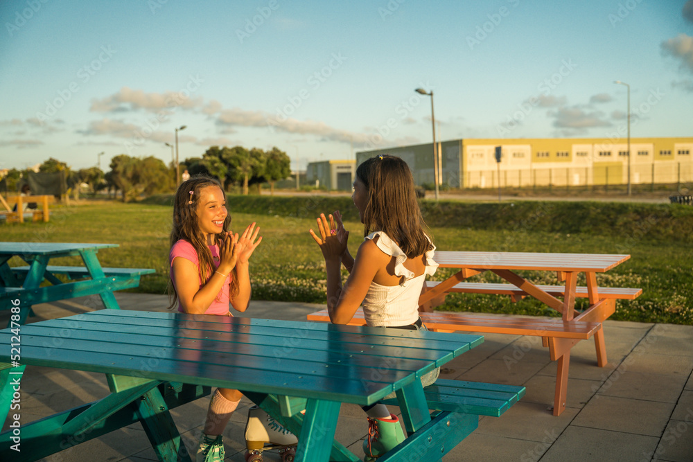 Two girls playing hand clapping game outdoors Photos | Adobe Stock