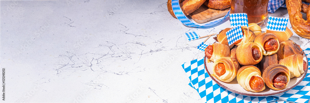 Oktoberfest party food. Pretzel hot dogs, puff pastry rolls with ...