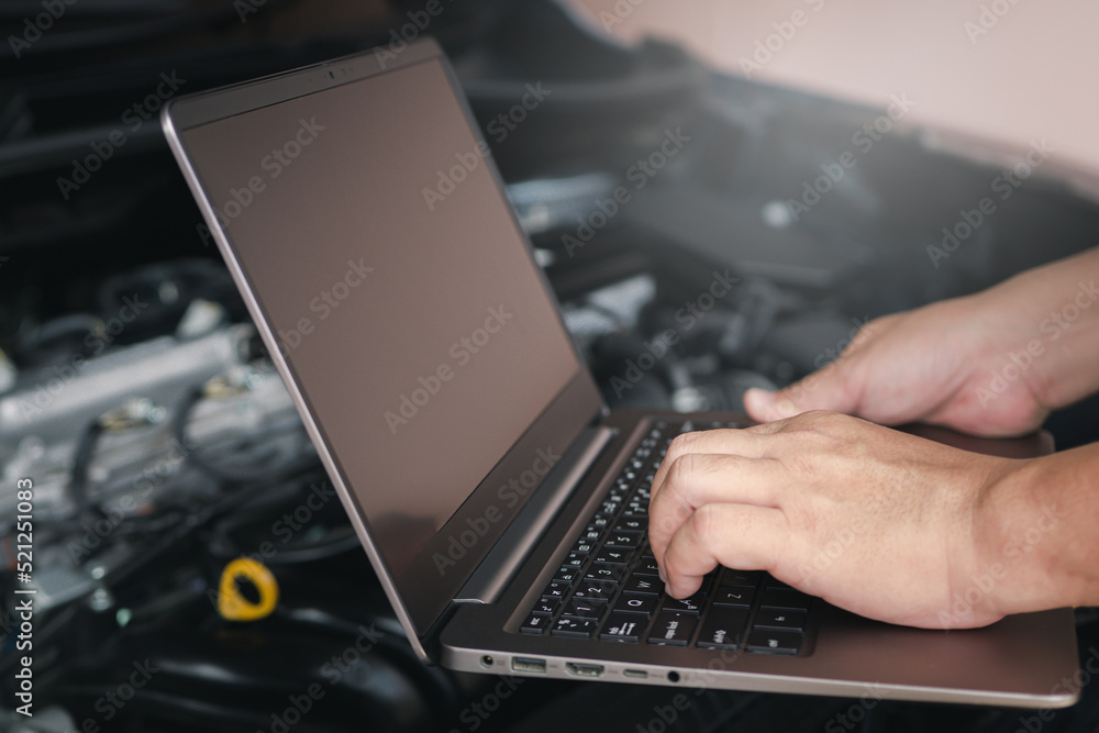 Mechanic using computer laptop for diagnostics engine. Repairing car ...