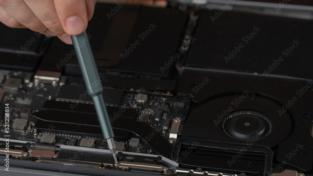 Repair and maintenance of computer laptop screwdriver unscrews the ...