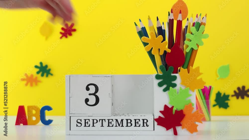 Wooden calendar with the date of September 30 on a table with a yellow ...