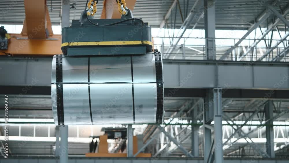 Loading sheet metal in a warehouse using a crane and an electromagnet ...