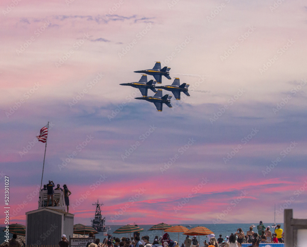 Four US Navy Blue Angels Jets flying in formation during sunset over a ...