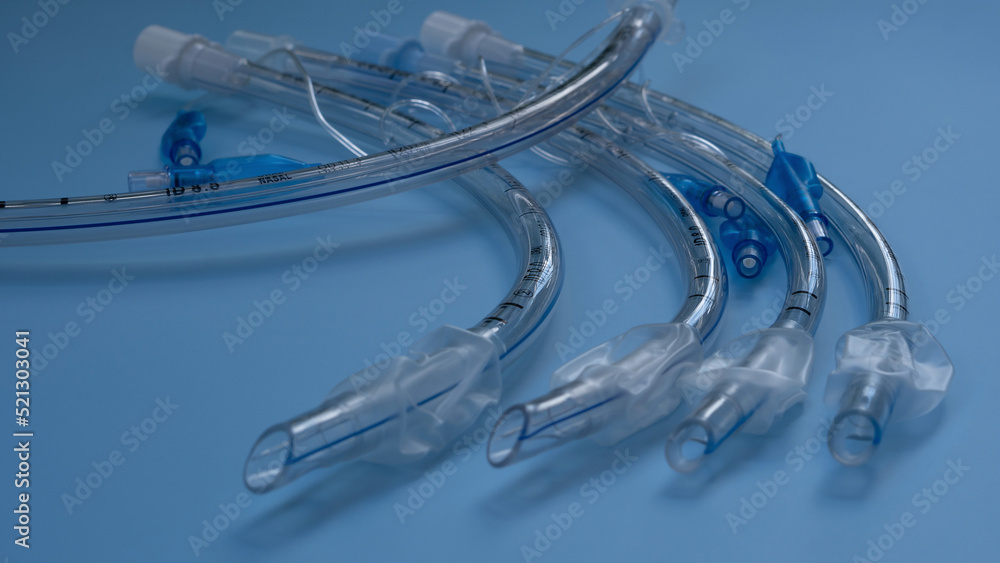 endotracheal tubes of different sizes and diameters lie on a light blue ...