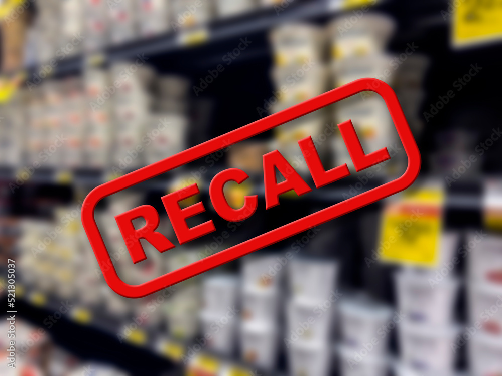 Blurry interior of a grocery store aisle behind large red Recall text ...