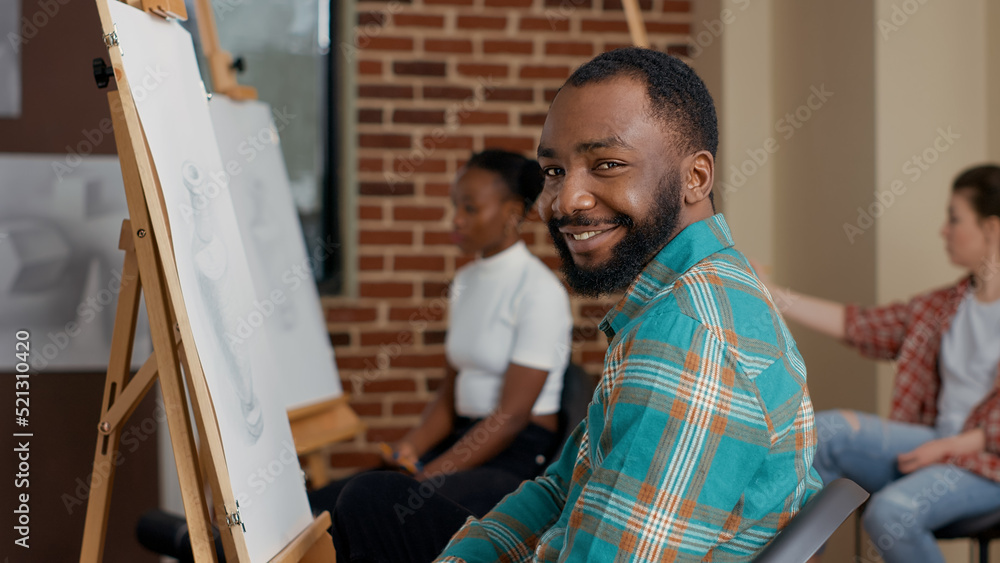 Portrait of young man learning to draw vase model at educational ...
