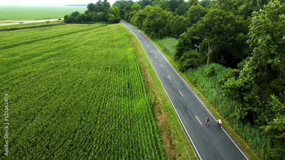 An aerial view of two cyclists pedaling on a secluded backcountry road ...