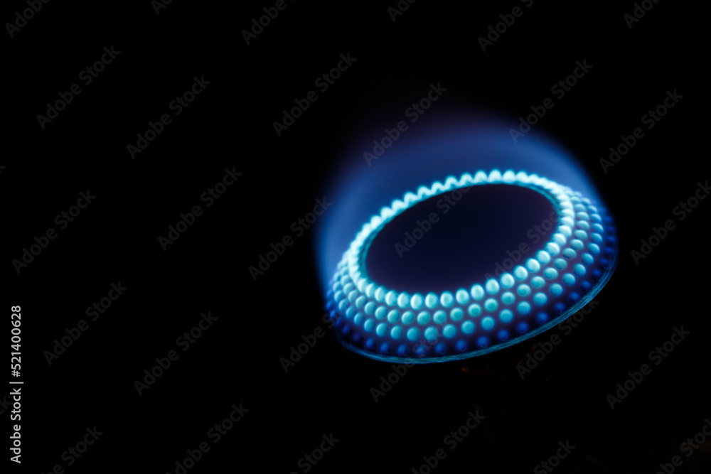 Gas burner with natural blue flame closeup on black background with ...