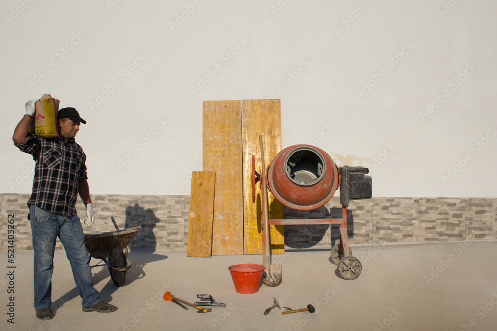 Image of a construction worker carrying a sack of cement on his ...