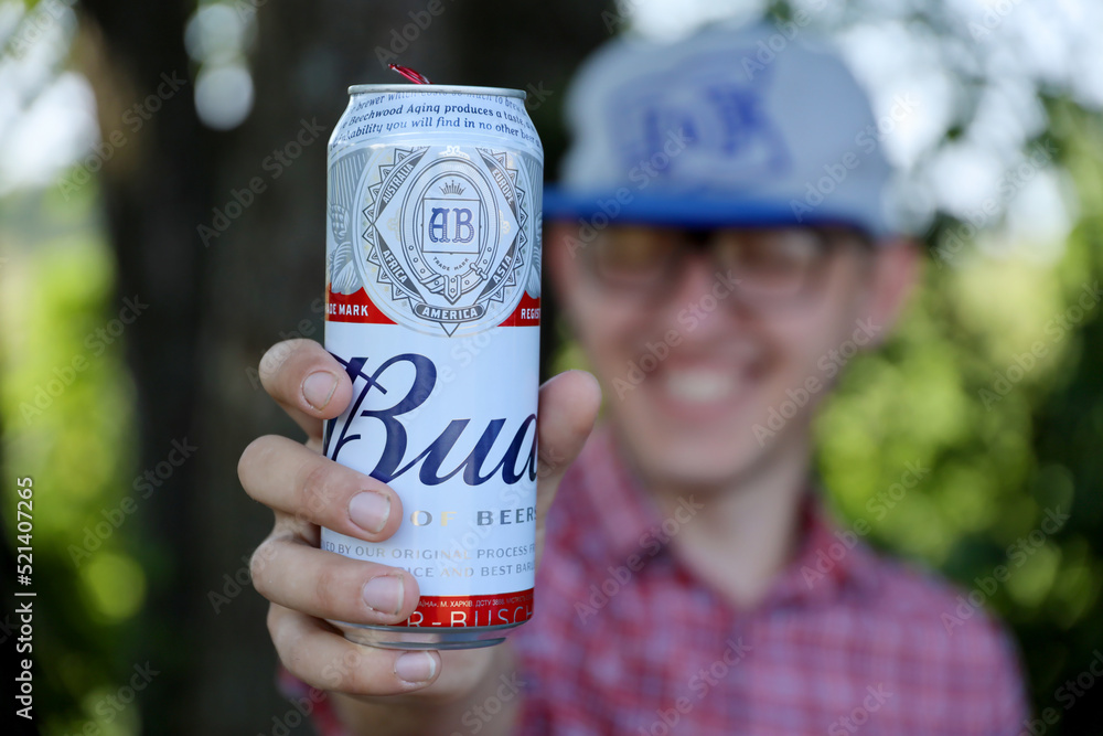 SUMY, UKRAINE - AUGUST 01, 2021: Young man raise Budweiser Bud beer can ...