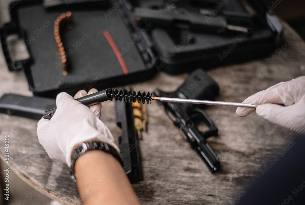 The gunsmith is sitting around cleaning the gun and disassembling and ...