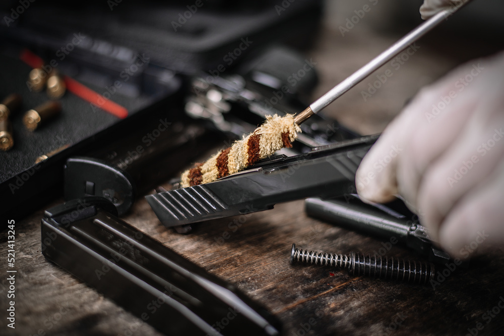 The gunsmith is sitting around cleaning the gun and disassembling and ...
