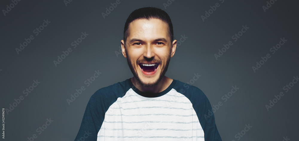 Studio portrait of young confident happy man. Panoramic banner view ...