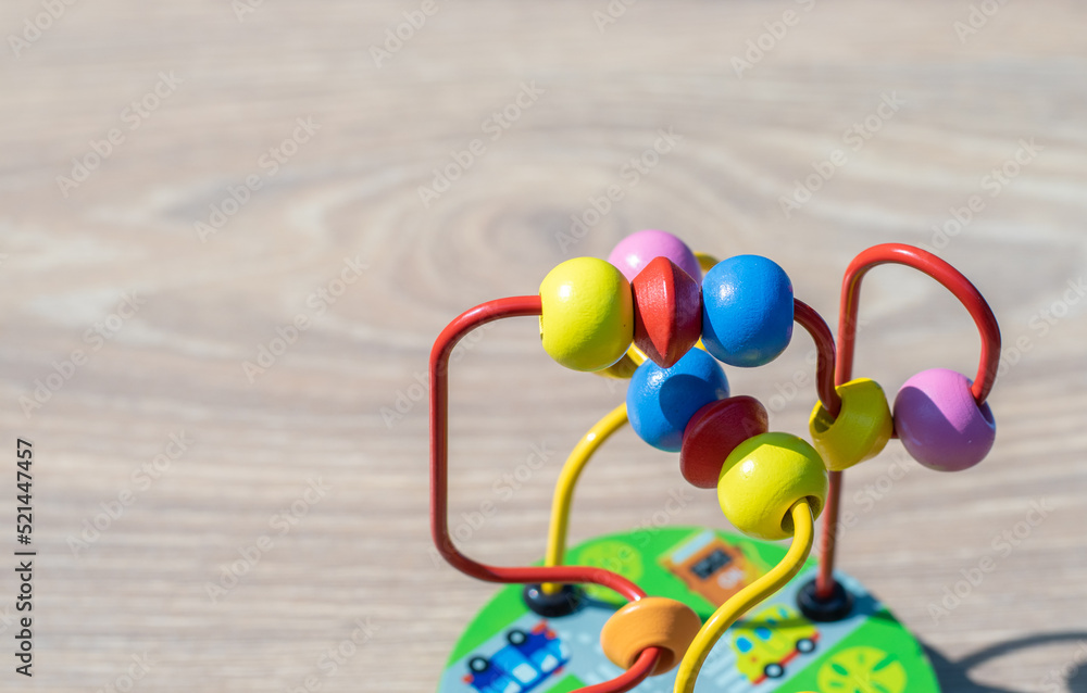 motoric loop toy for baby on wooden laminate floor in sunshine daylight ...