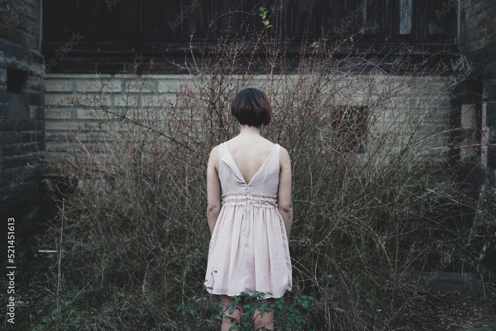 dramatic portrait scene short-haired woman from the back in front of an ...