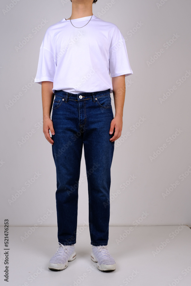 slender man in spring street clothes: skinny blue jeans and a white T ...