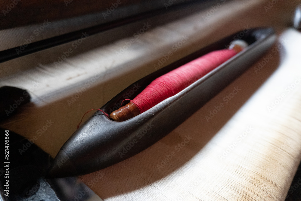 Fotografia do Stock: Weaving shuttle with bobbin of red thread on a ...