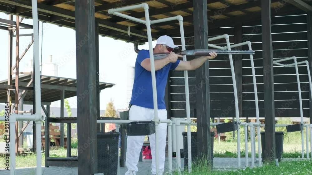 Sportsman shoots from a double-barreled shotgun, A sports field for a ...
