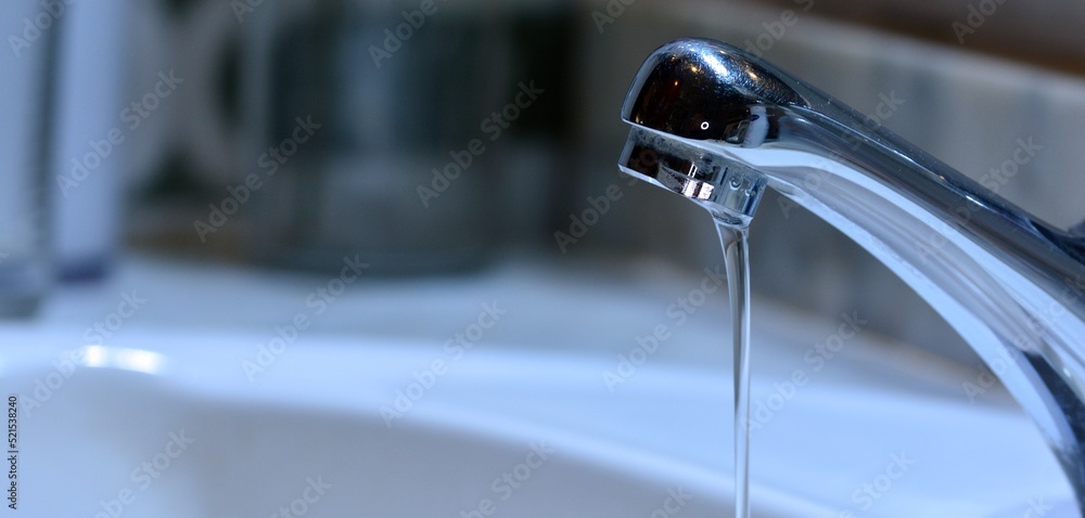Pequeño chorro de agua cayendo de un grifo Stock Photo | Adobe Stock