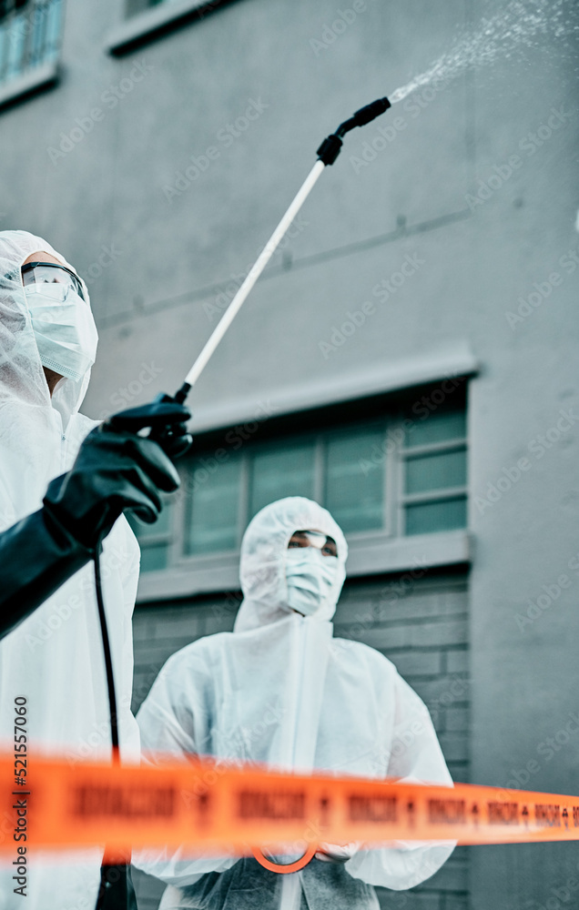Healthcare workers wearing hazmat suits disinfecting a building during ...