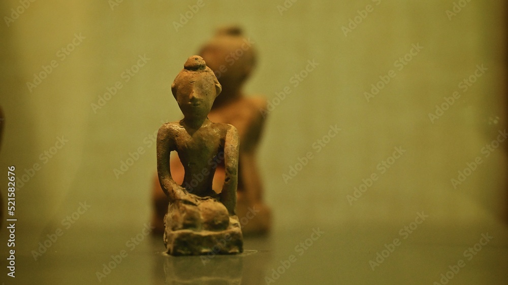 The statue of a small woman is an ancient object in the temple. Stock ...