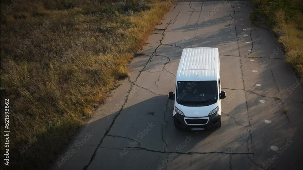 Aerial drone footage of a white van driving on a country road Stock ...