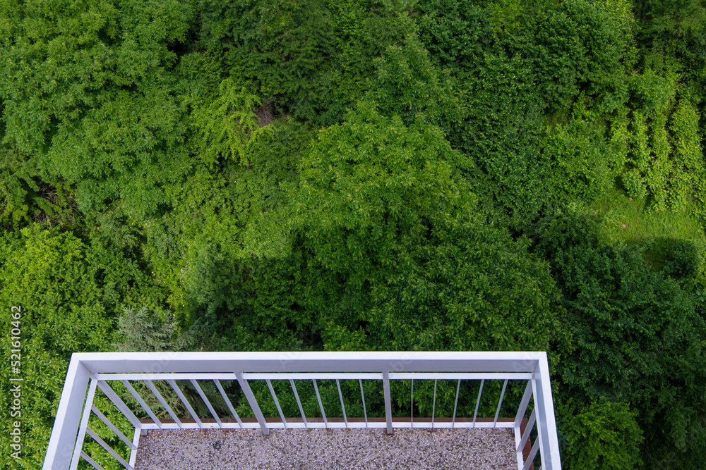 Residential building balcony or terrace view of green forest thick tree ...
