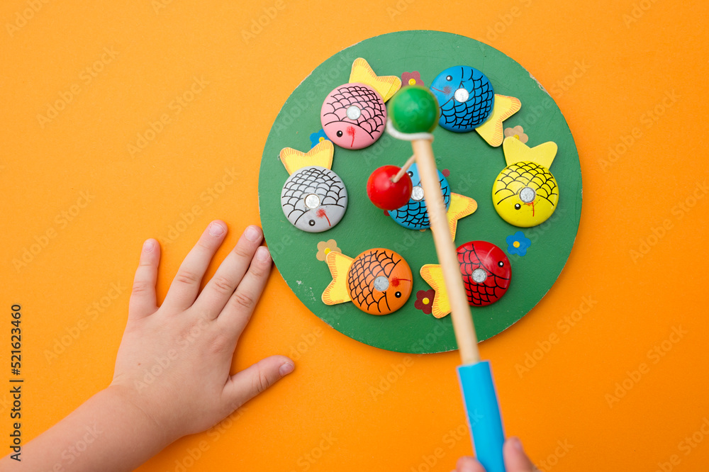 Let's go fishing. Wooden fishes and fishing rod with magnet on the tip ...