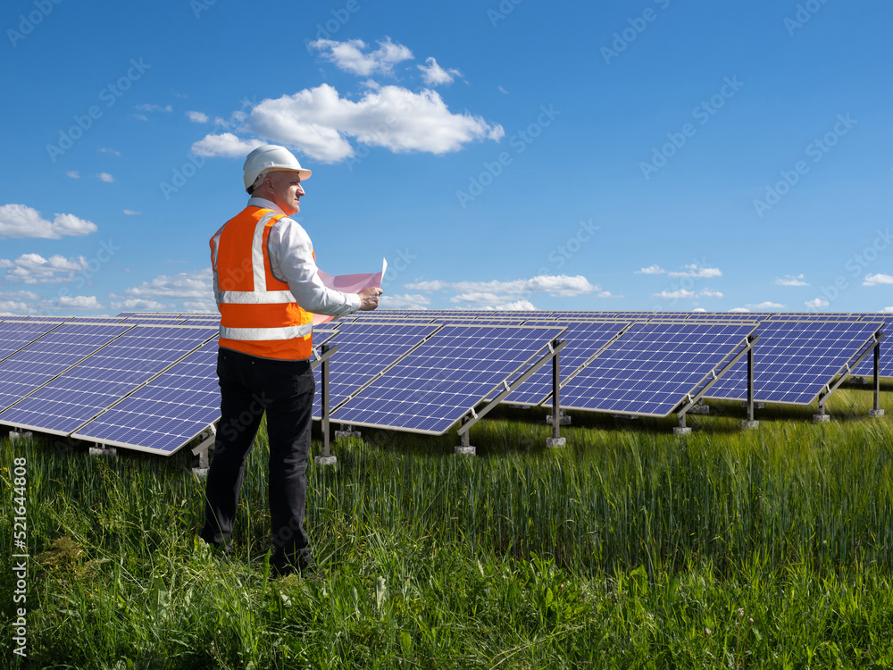Installation of solar panels. Energy company employee. Man in orange ...