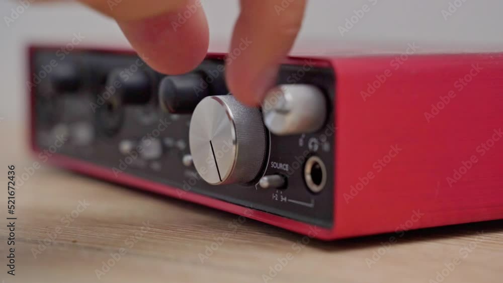 A close-up of a man turns the volume knob in a special device to make ...