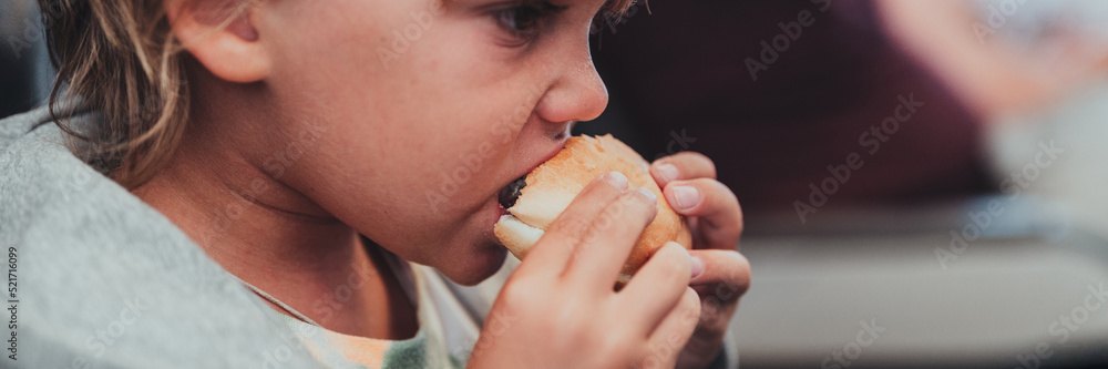 little candid kid boy five year old eats burger or sandwich food ...