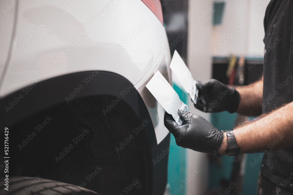 man holding 2 palettes with color samples near modern car, inspector ...