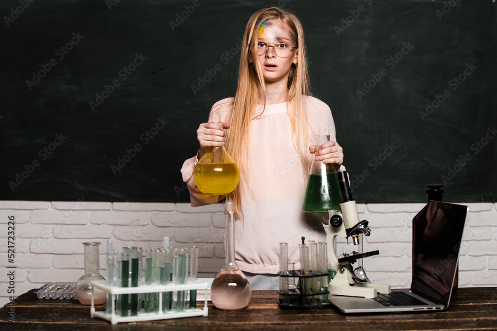 Funny little school child doing experiments in the laboratory ...