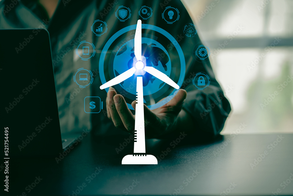 Young man sitting at home working on energy saving projects and wind ...