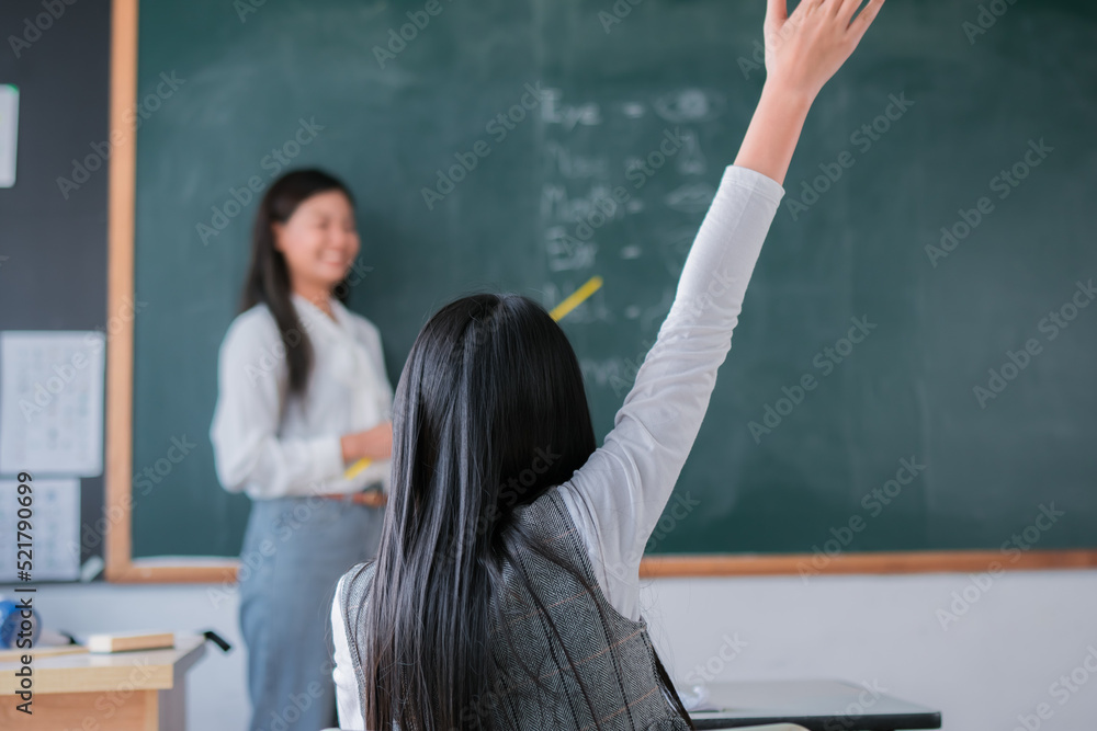 Raising hand of asian girl student answer in classroom school ...