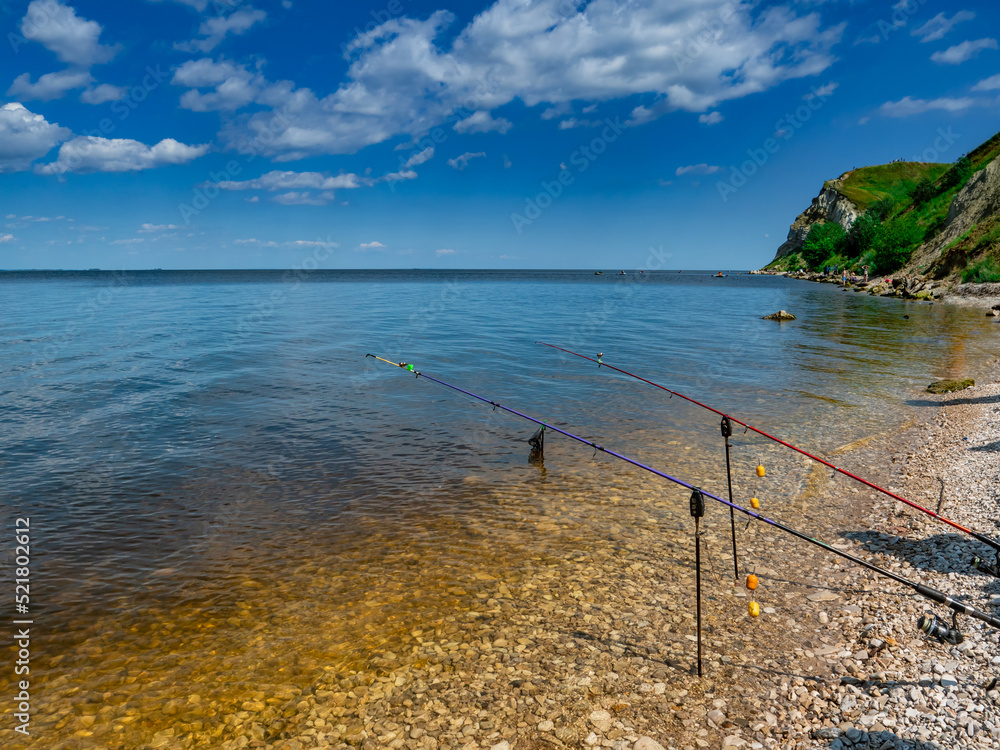 Two fishing rods on the beach. Fshing from shore. The concept of a ...