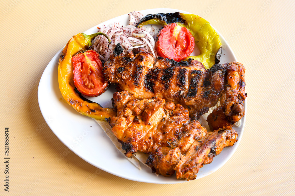 A skewered chicken kebob with grilled onions, bell peppers and ...