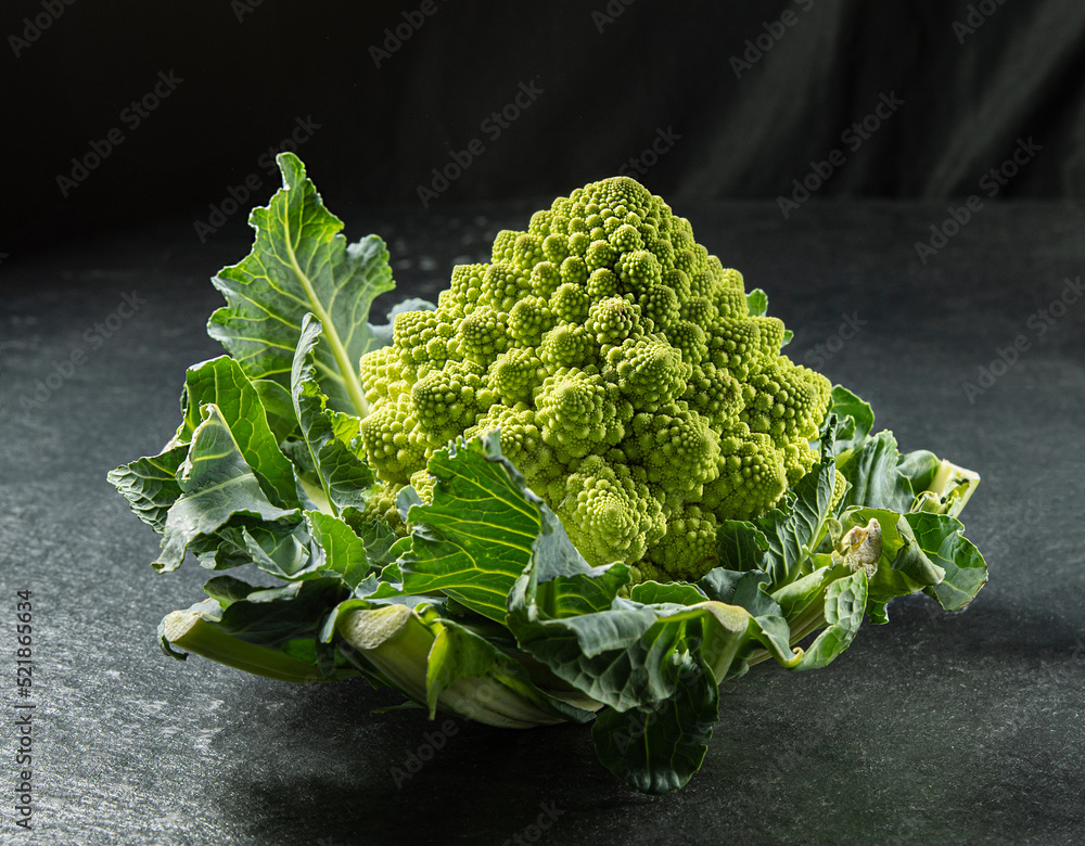 Romanesco broccoli head on a dark stone surface, cabbage, close up ...