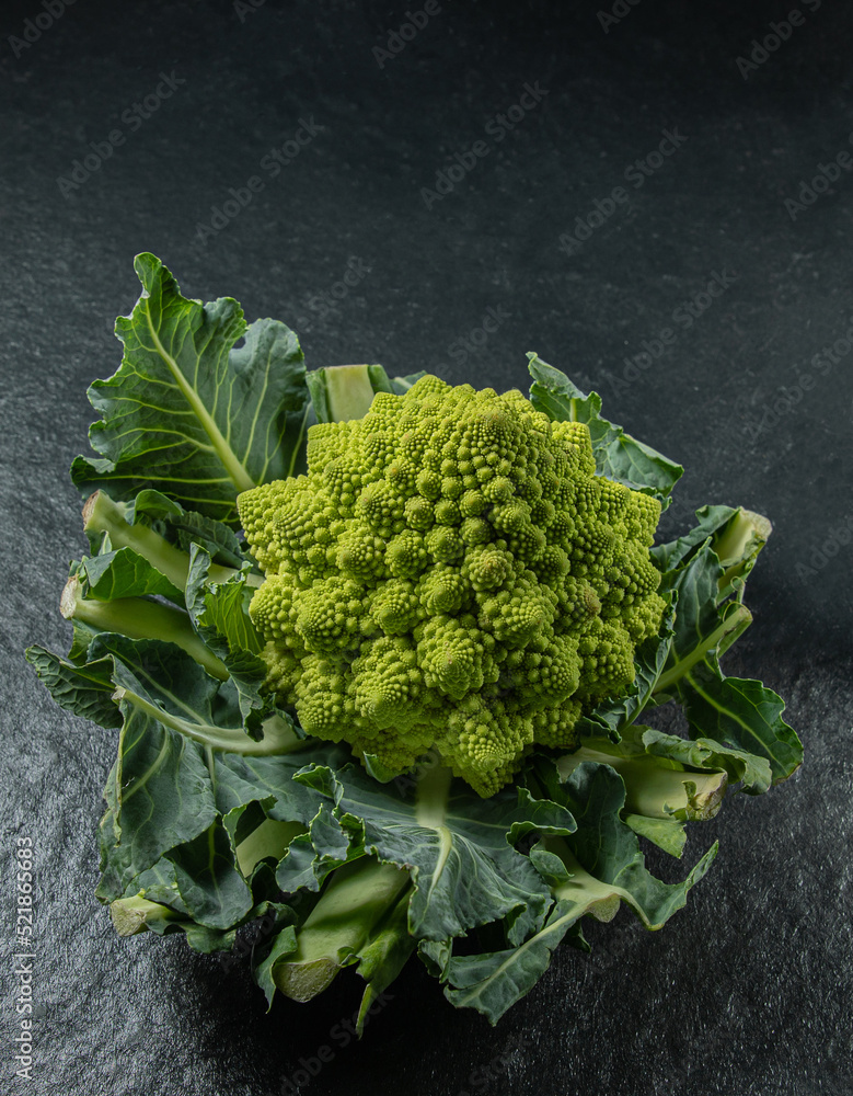 Romanesco broccoli head on a dark stone surface, cabbage, close up ...