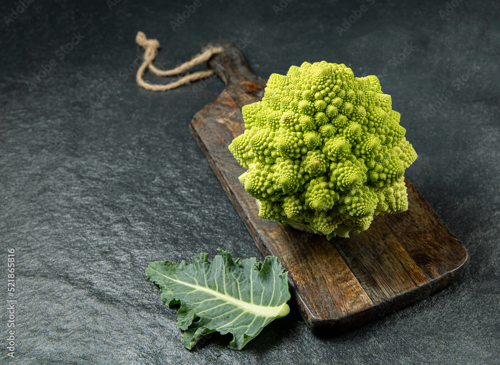 Romanesco broccoli head on a dark stone surface, cabbage, close up ...