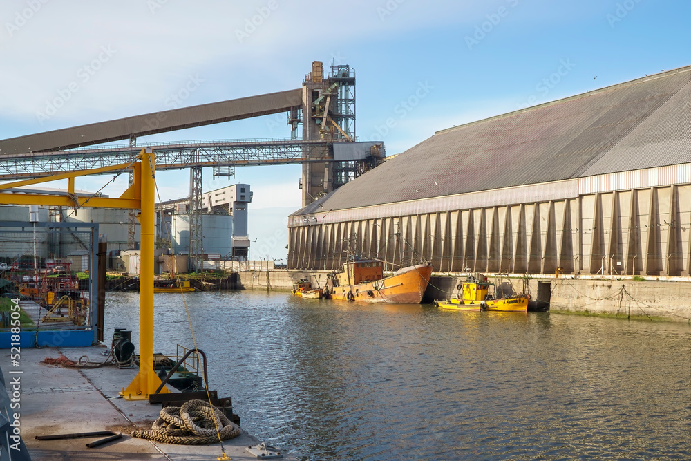 Maritime harbor with grain loading dock, shed and silos. Some small ...