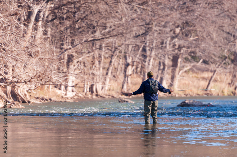 An angler casts his fly fishing rod for trout in the scenic Guadalupe ...