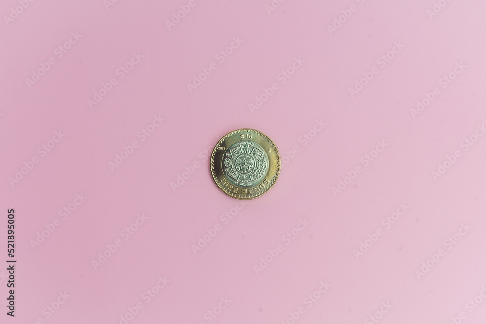 Moneda de 10 pesos mexicanos sobre fondo rosa. Stock Photo | Adobe Stock