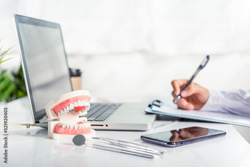Oral dental. Dentist doctor in uniform writing information of patient ...