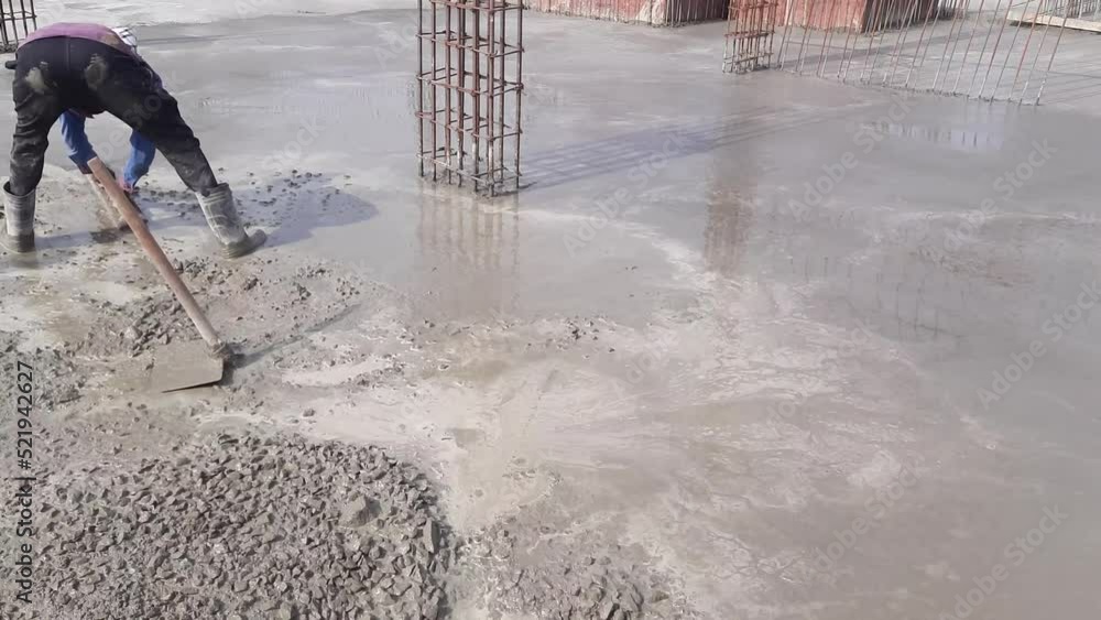 A worker Leveling PCC Foundation Concrete slab On A New Building ...