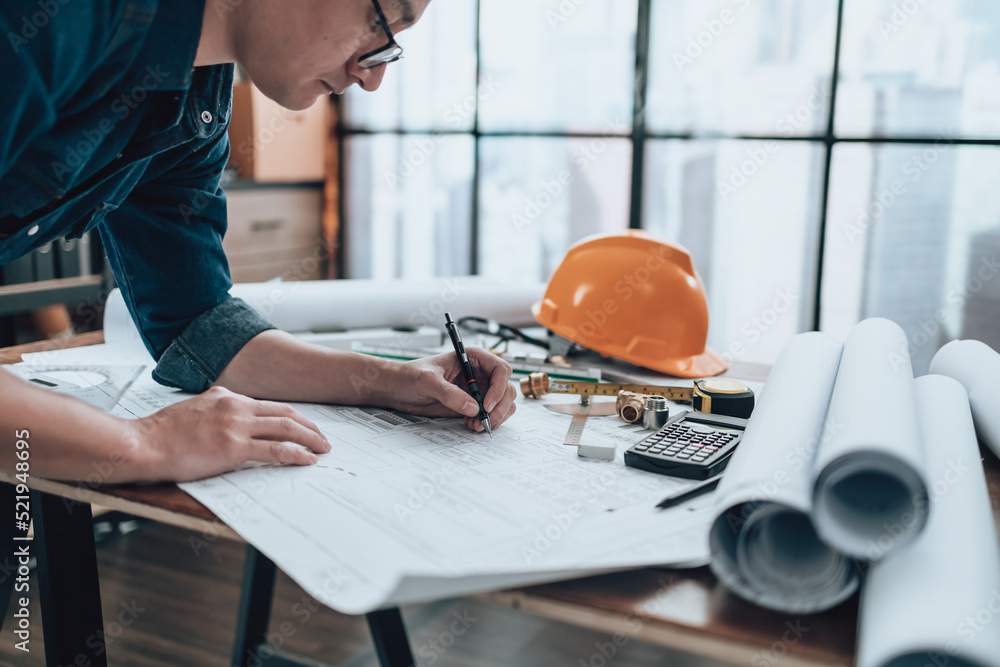 Engineering working with drawings inspection and writing on the office ...