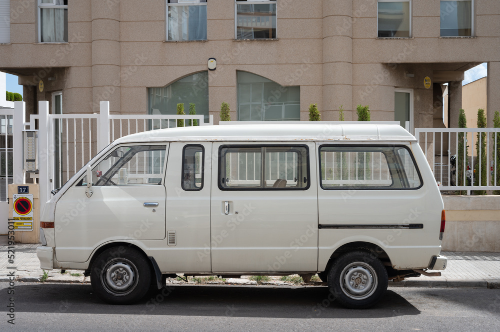 Detail of an old white van, it is a Nissan Vanette parked on the street ...