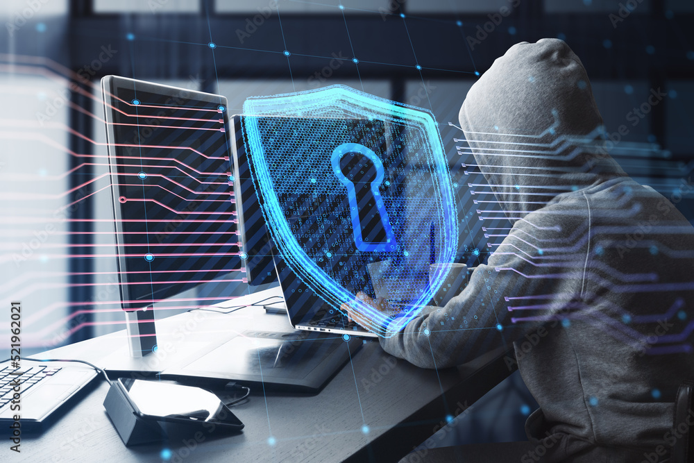 Side view of hacker at desktop using computers with creative glowing shield circuit security ...